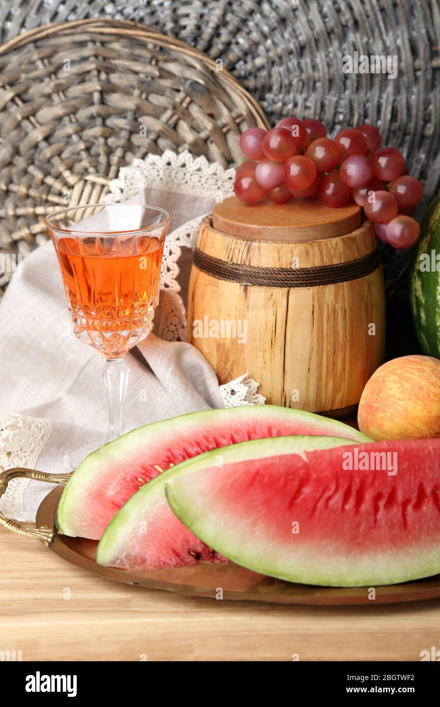 Composition of ripe watermelon, fruits, pink wine in glass and wooden ...