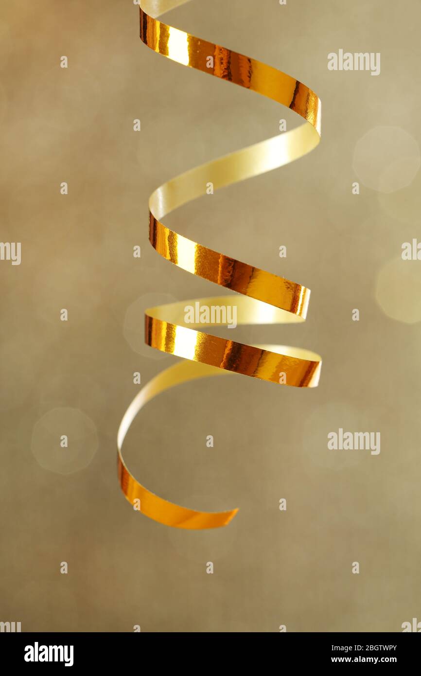 Serpentine ribbon on golden shiny background Stock Photo - Alamy