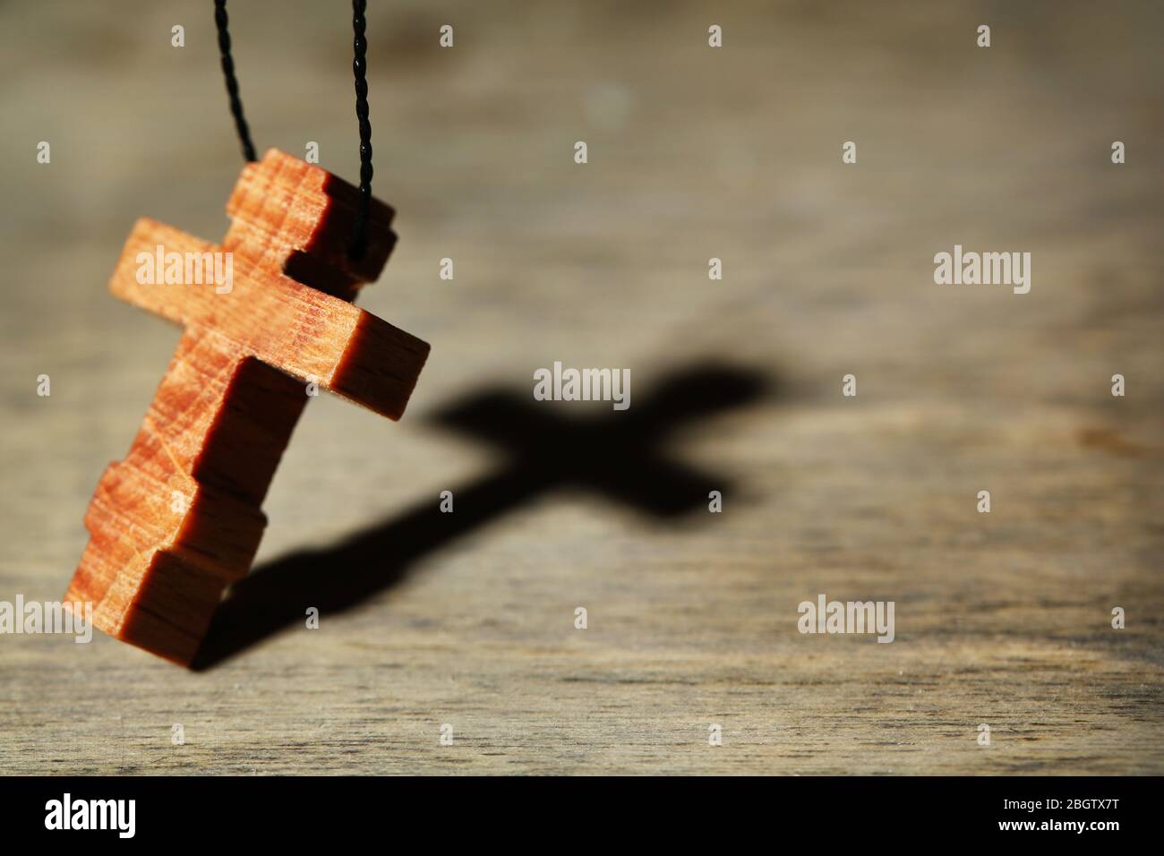 Wooden cross with deep shadow on wooden background Stock Photo - Alamy