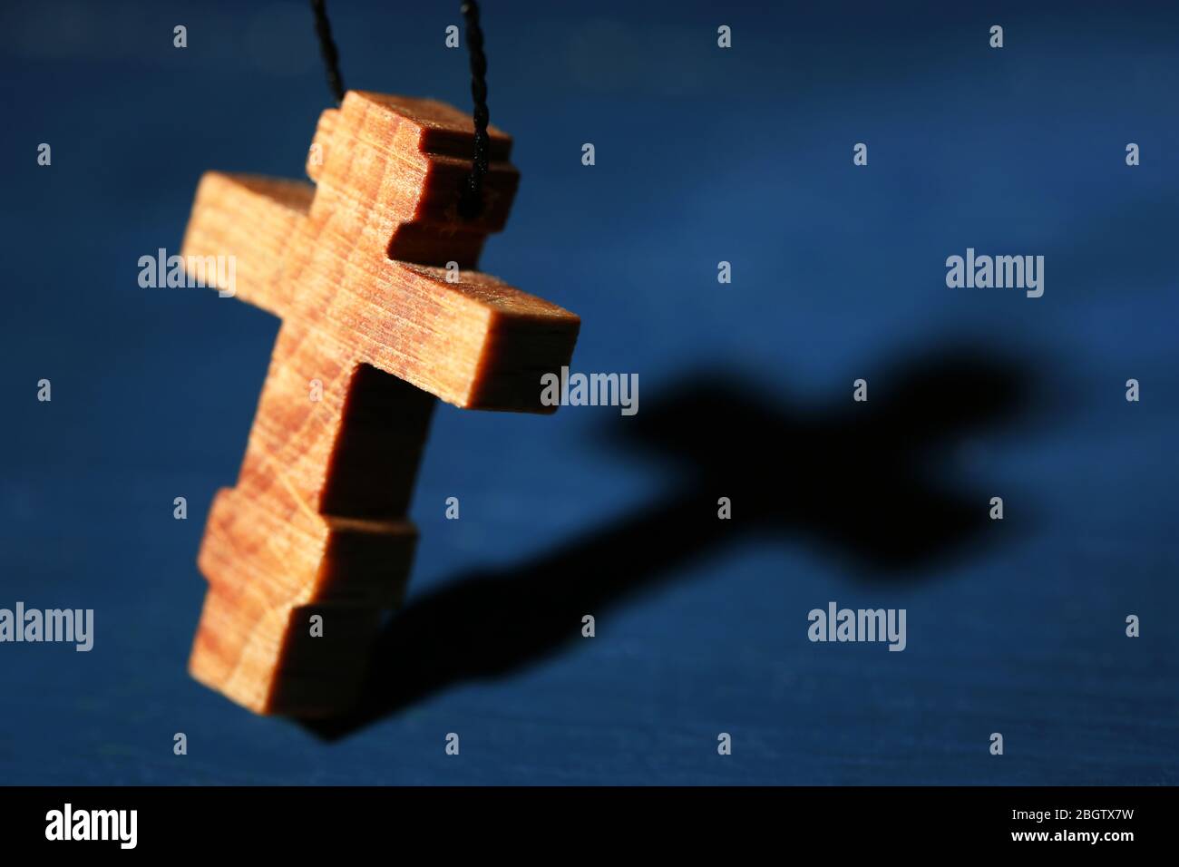 Wooden cross with deep shadow on wooden background Stock Photo - Alamy