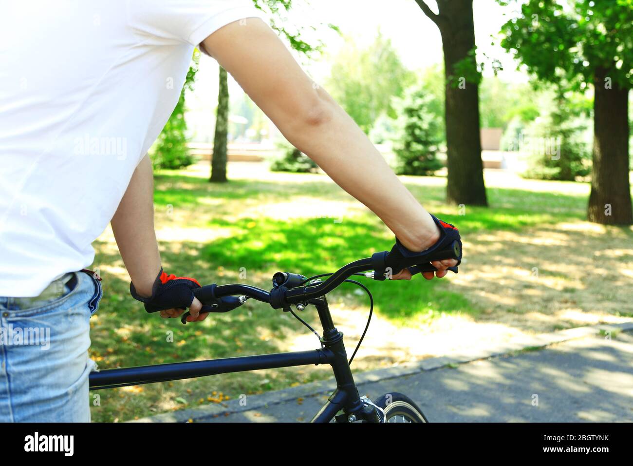Young man riding bike in city park Stock Photo - Alamy
