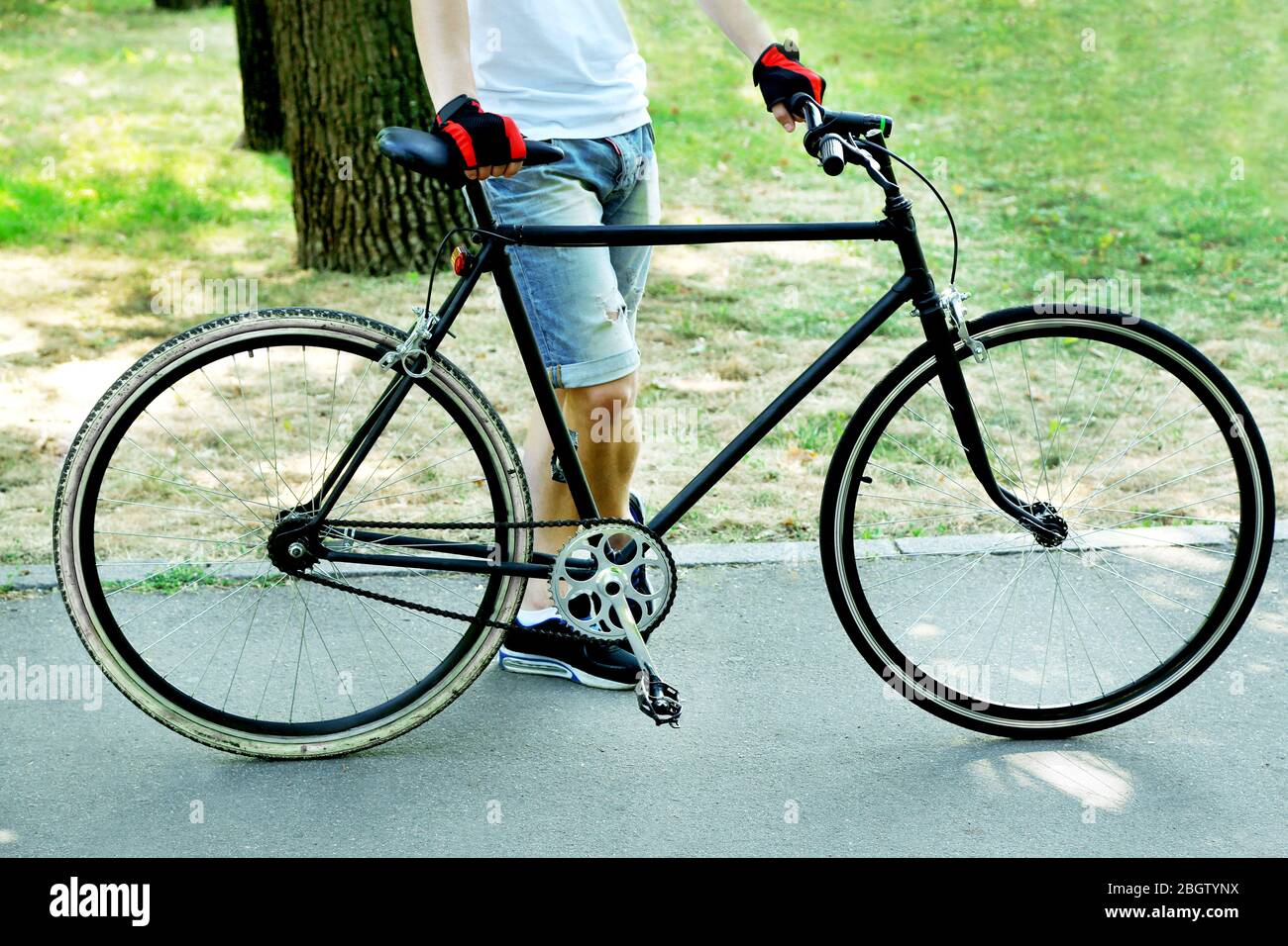 Young man riding bike in city park Stock Photo - Alamy