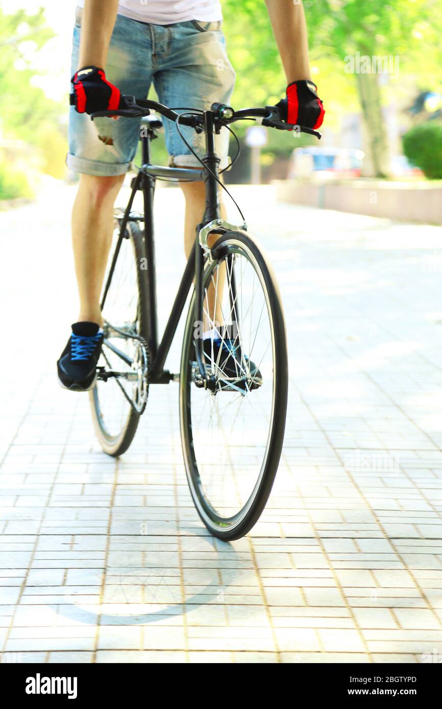 Young man riding bike in city park Stock Photo - Alamy