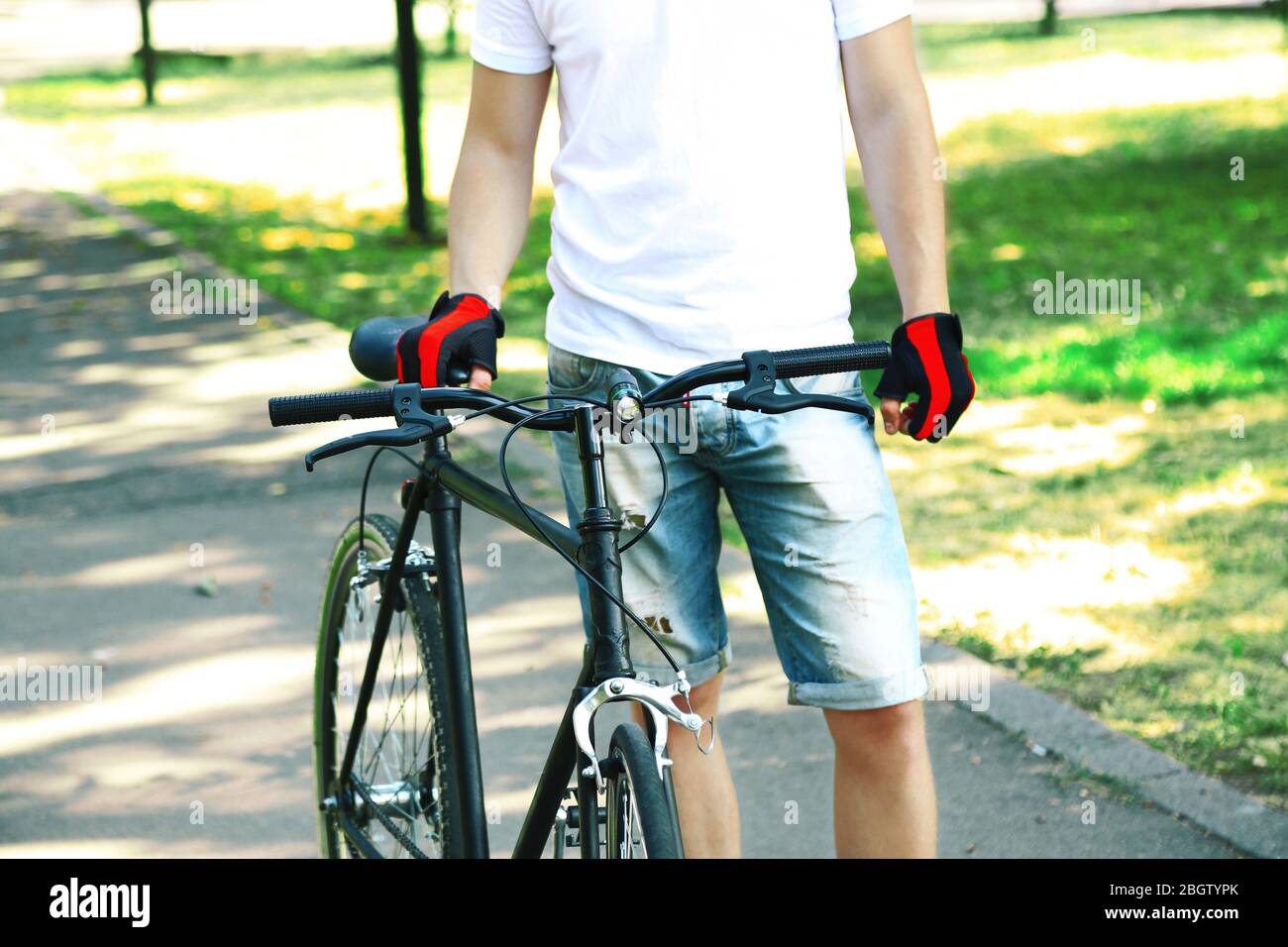 Young man riding bike in city park Stock Photo - Alamy