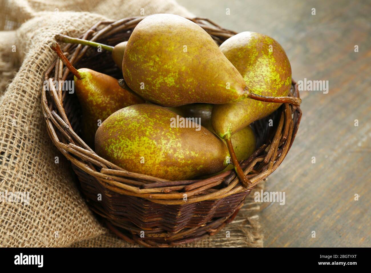 Ripe pears in wicker basket, on wooden background Stock Photo - Alamy