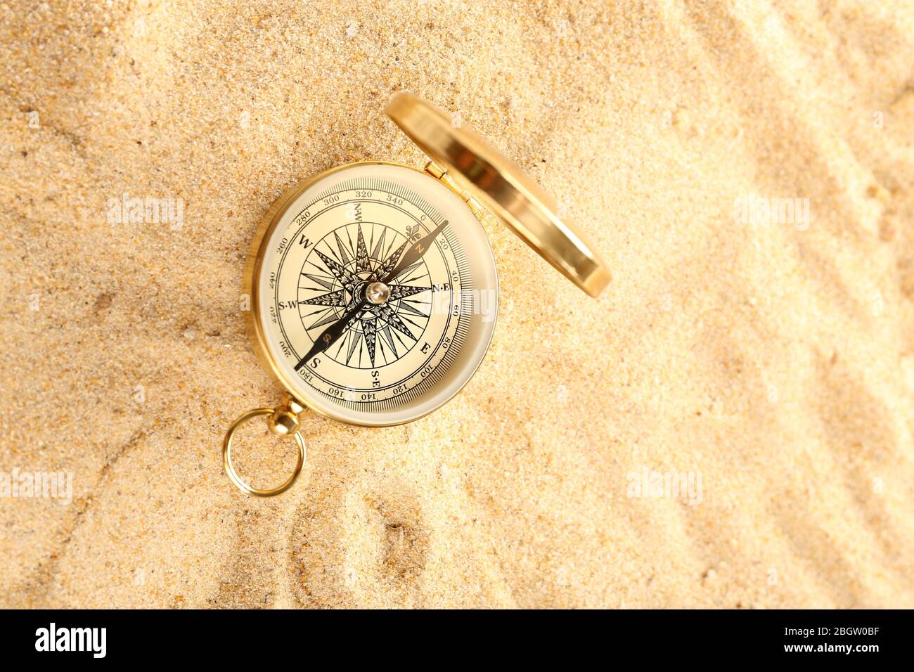 Compass on sand close-up Stock Photo - Alamy