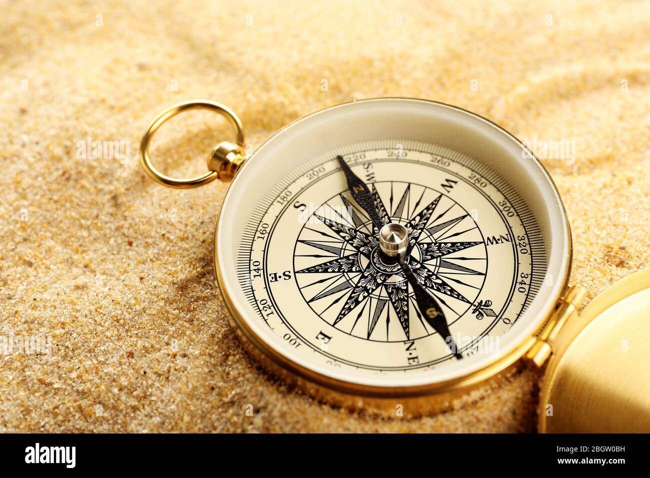 Compass on sand close-up Stock Photo - Alamy