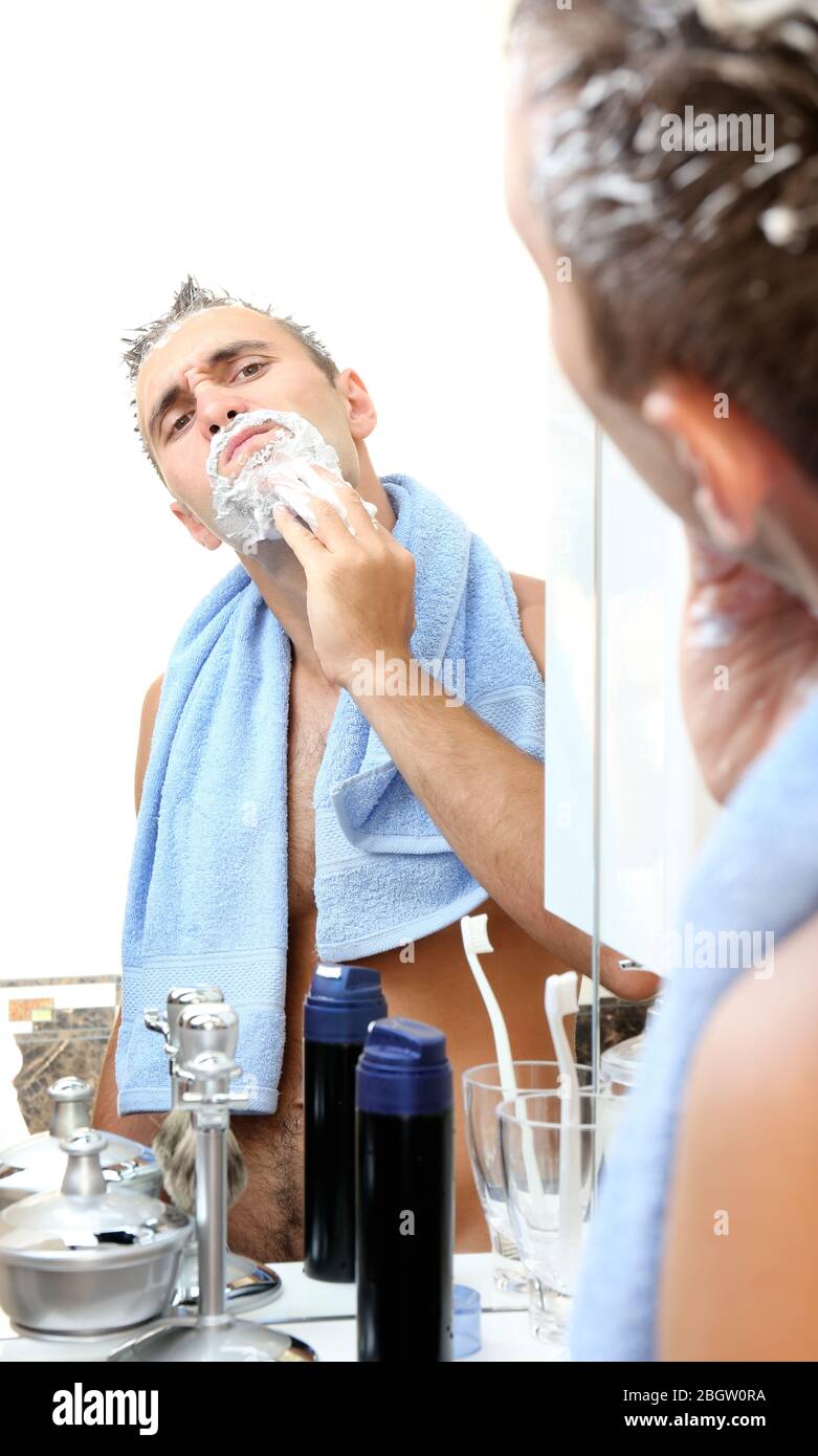 Young man shaving his beard in bathroom Stock Photo - Alamy
