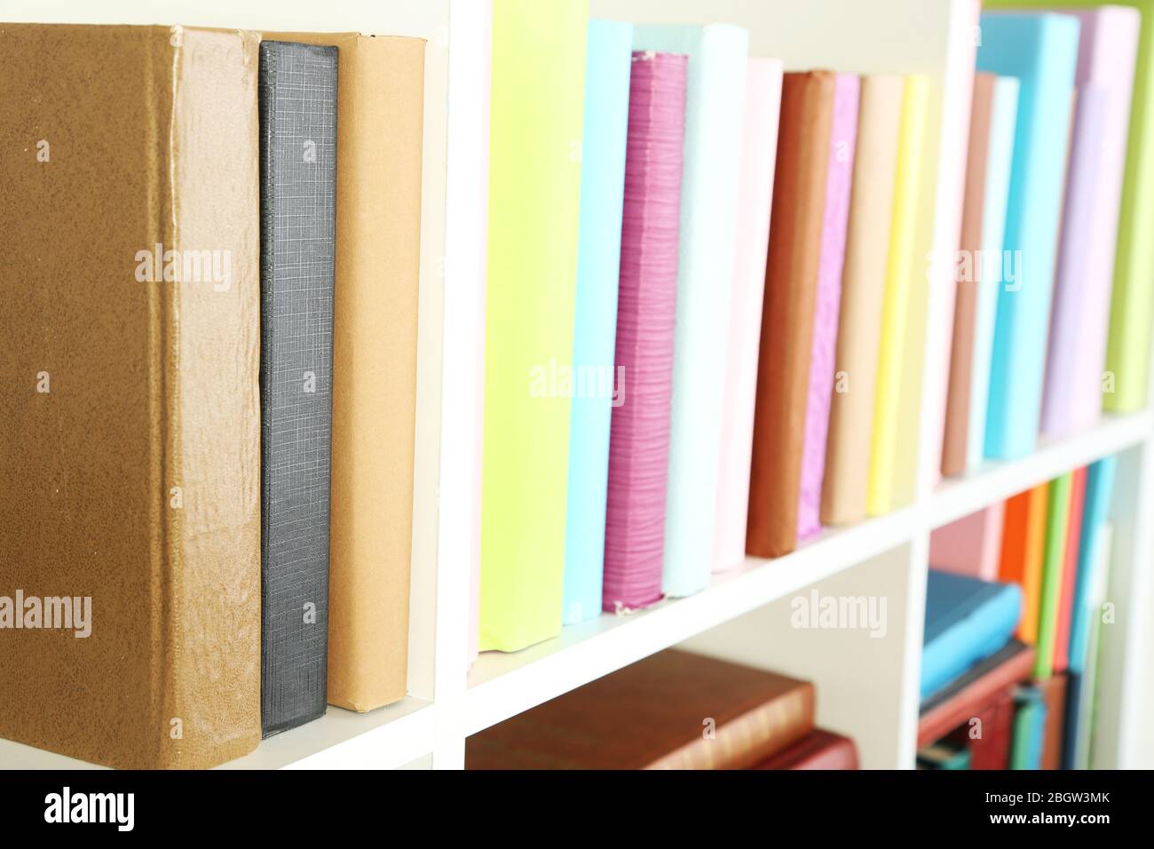 Hand picking book in library Stock Photo - Alamy