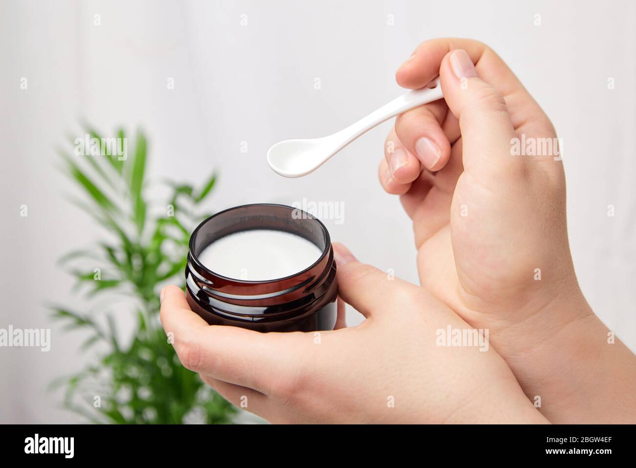 Shea butter in jar, cosmetic product for moisturizing skin. Female hand ...