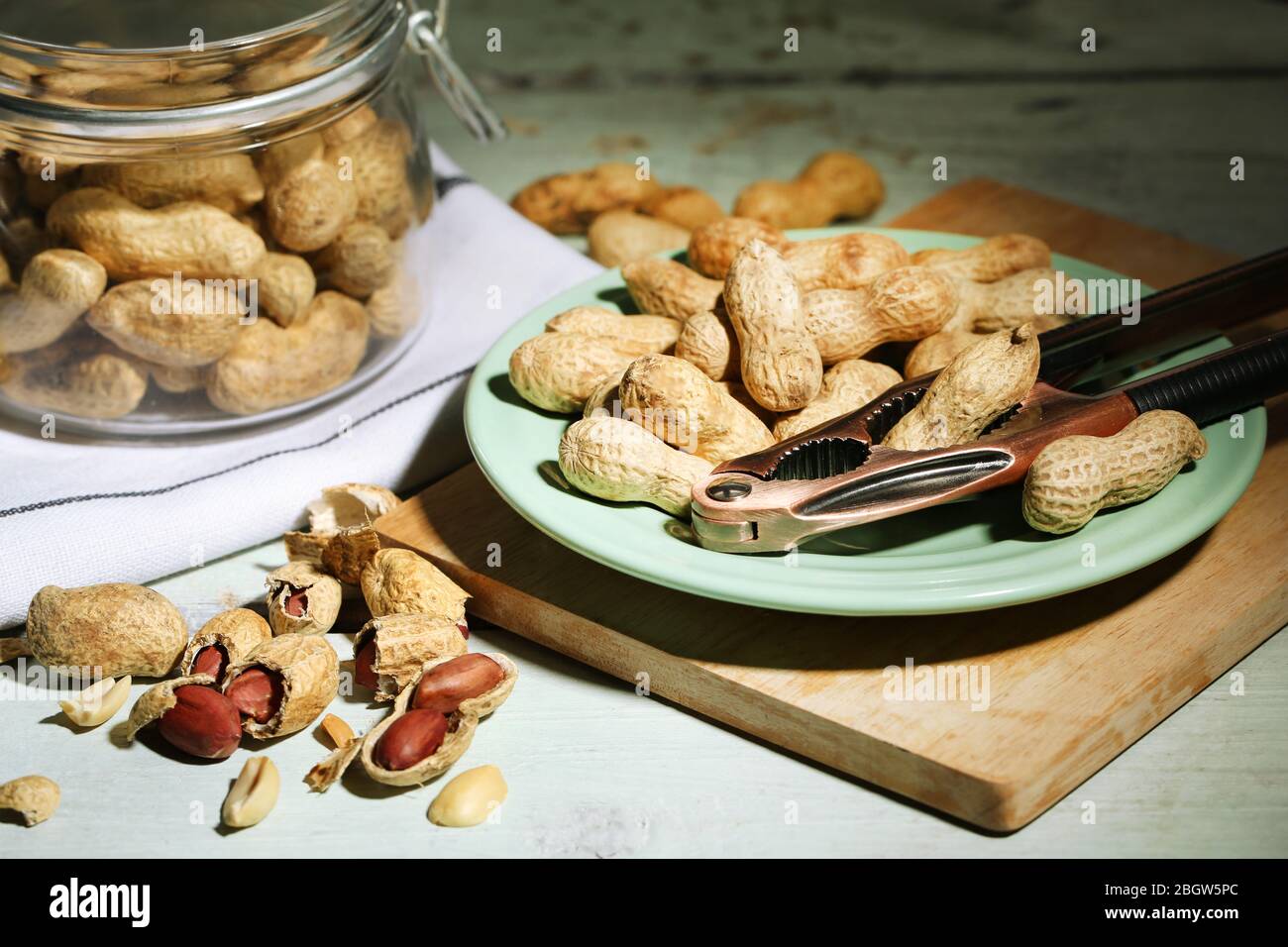 Peanuts and nutcracker on plate, on wooden background Stock Photo - Alamy