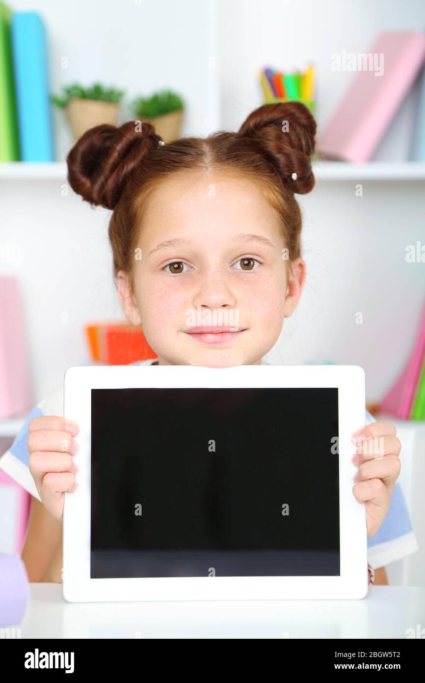 Cute girl with tablet at workplace in classroom Stock Photo - Alamy