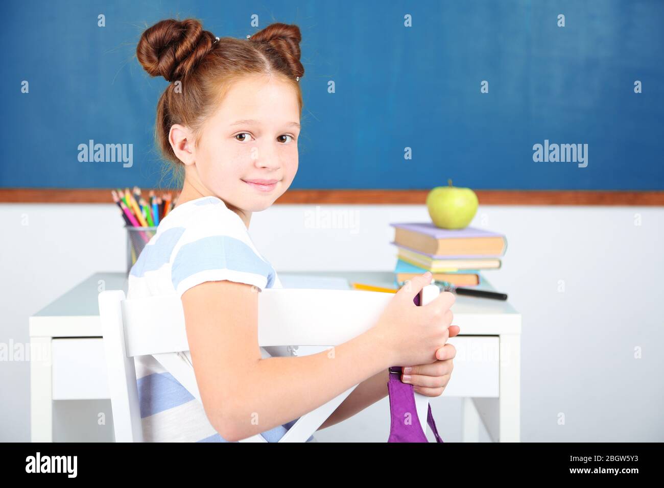 Cute girl at workplace in classroom Stock Photo - Alamy