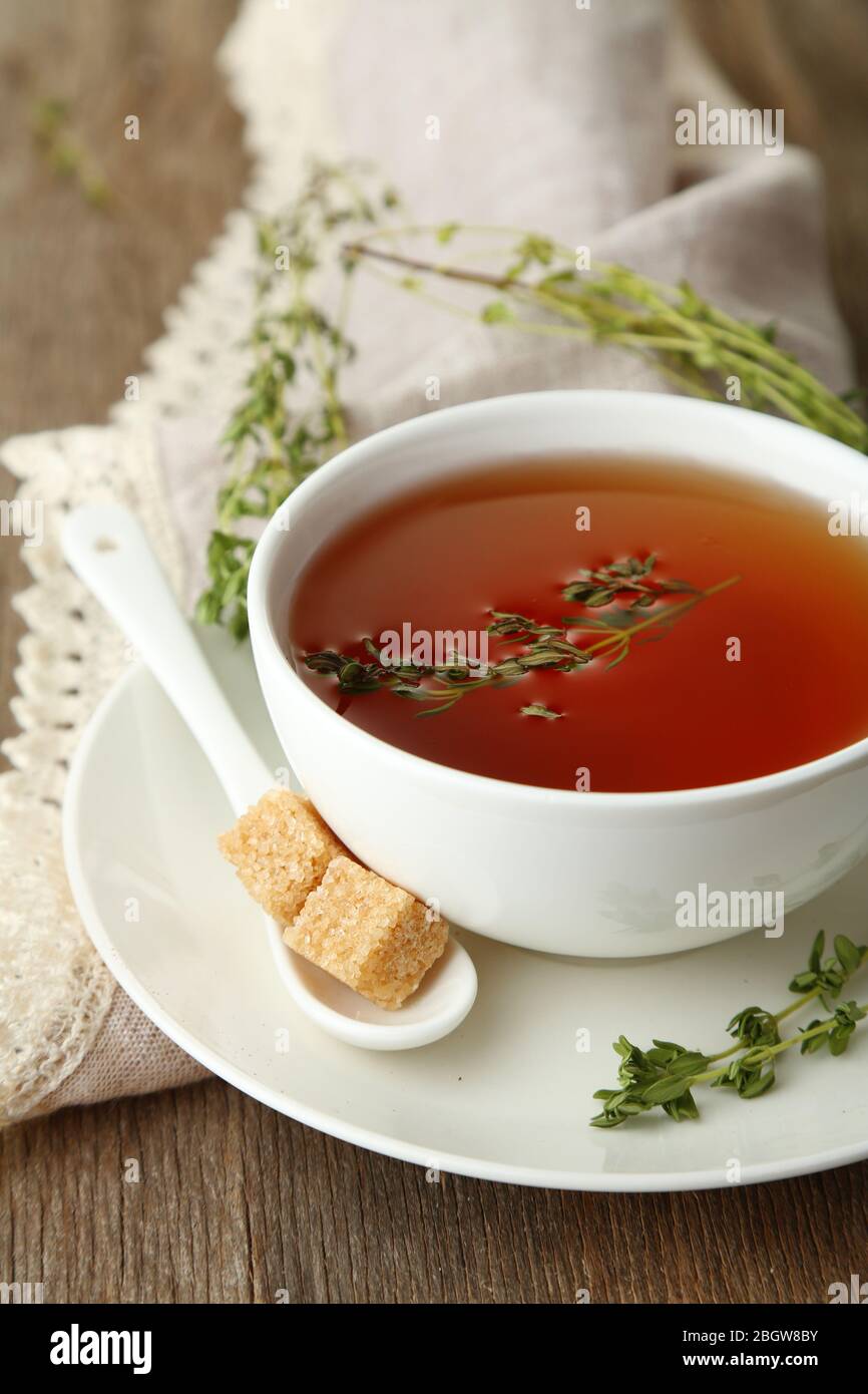 Cup of tasty herbal tea with thyme on wooden table Stock Photo - Alamy