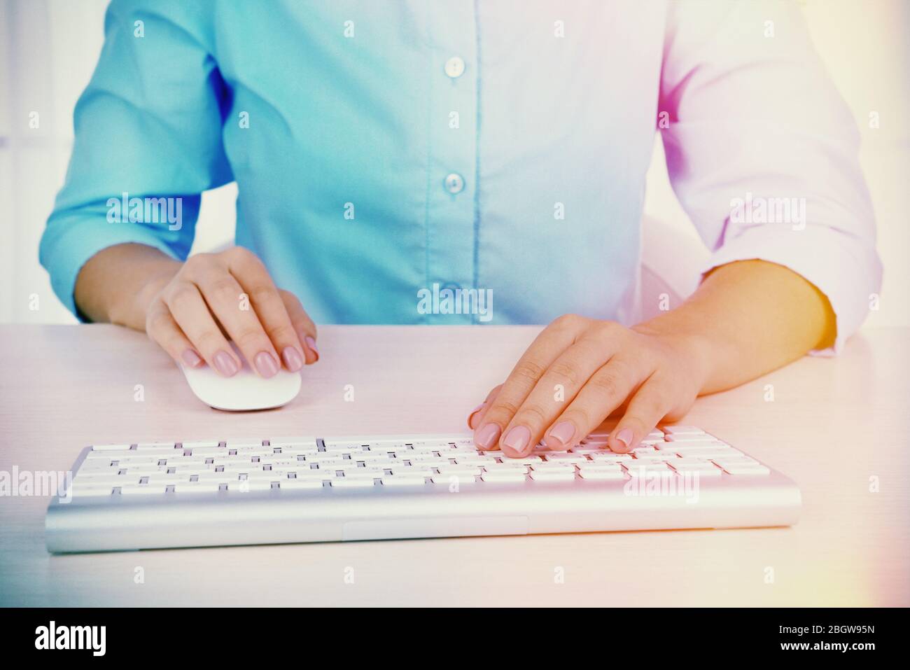 Female hands typing on keyboard on light background Stock Photo - Alamy
