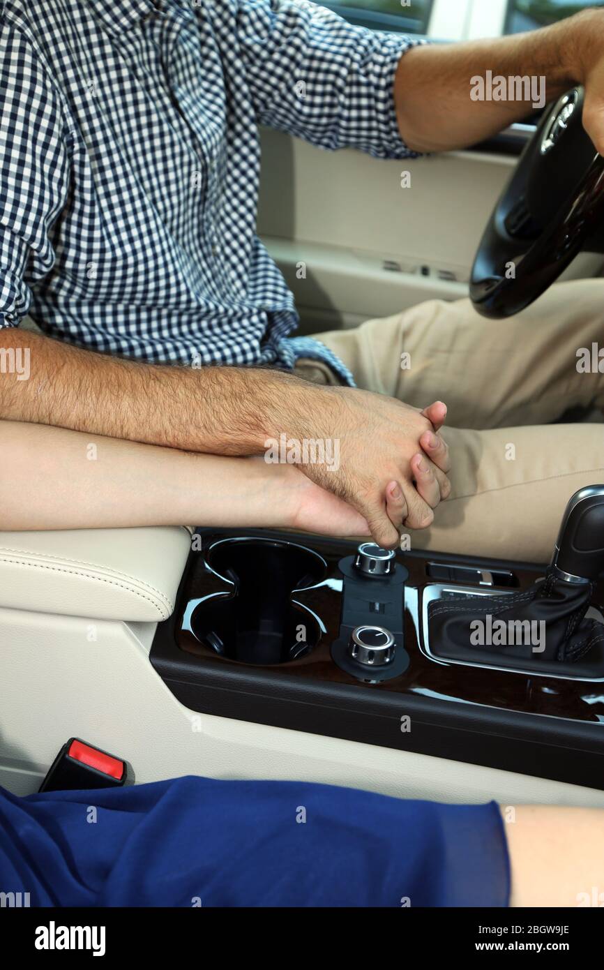 Loving couple holding hands in car close-up Stock Photo - Alamy