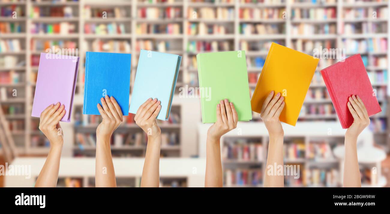 Female hands with books in modern library Stock Photo - Alamy