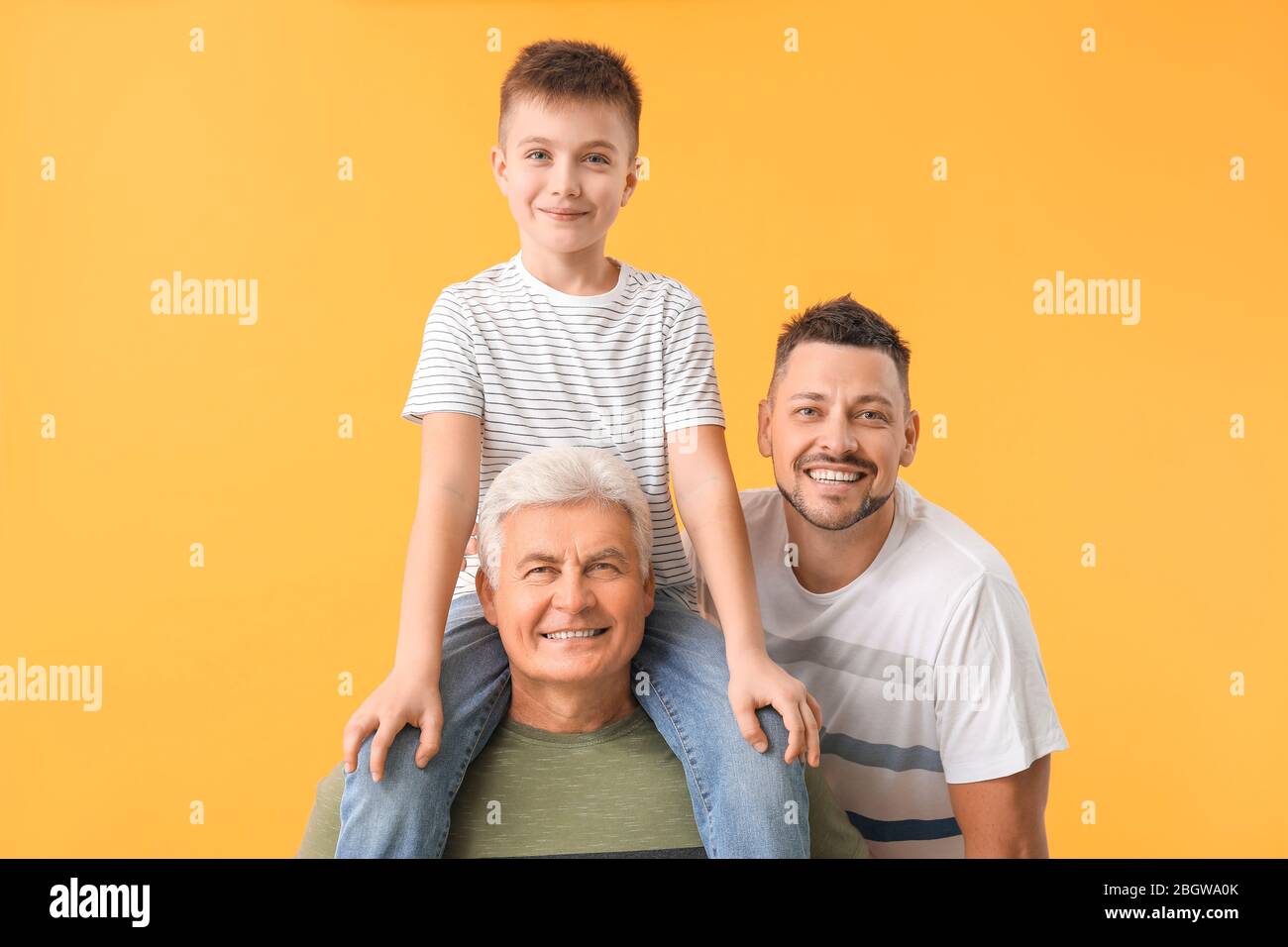 Man with his father and son on color background Stock Photo - Alamy