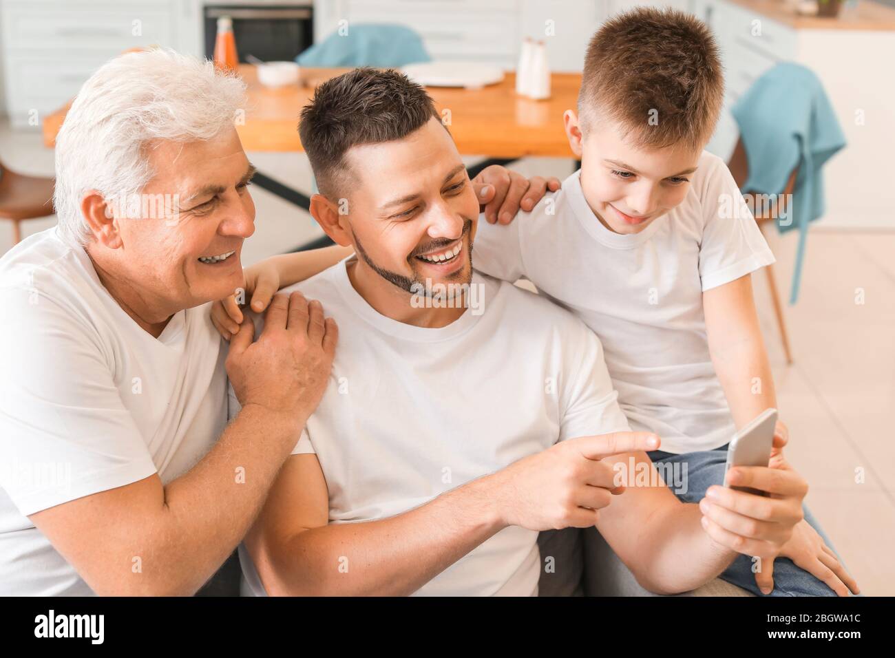 Man with his father and son using mobile phone at home Stock Photo - Alamy