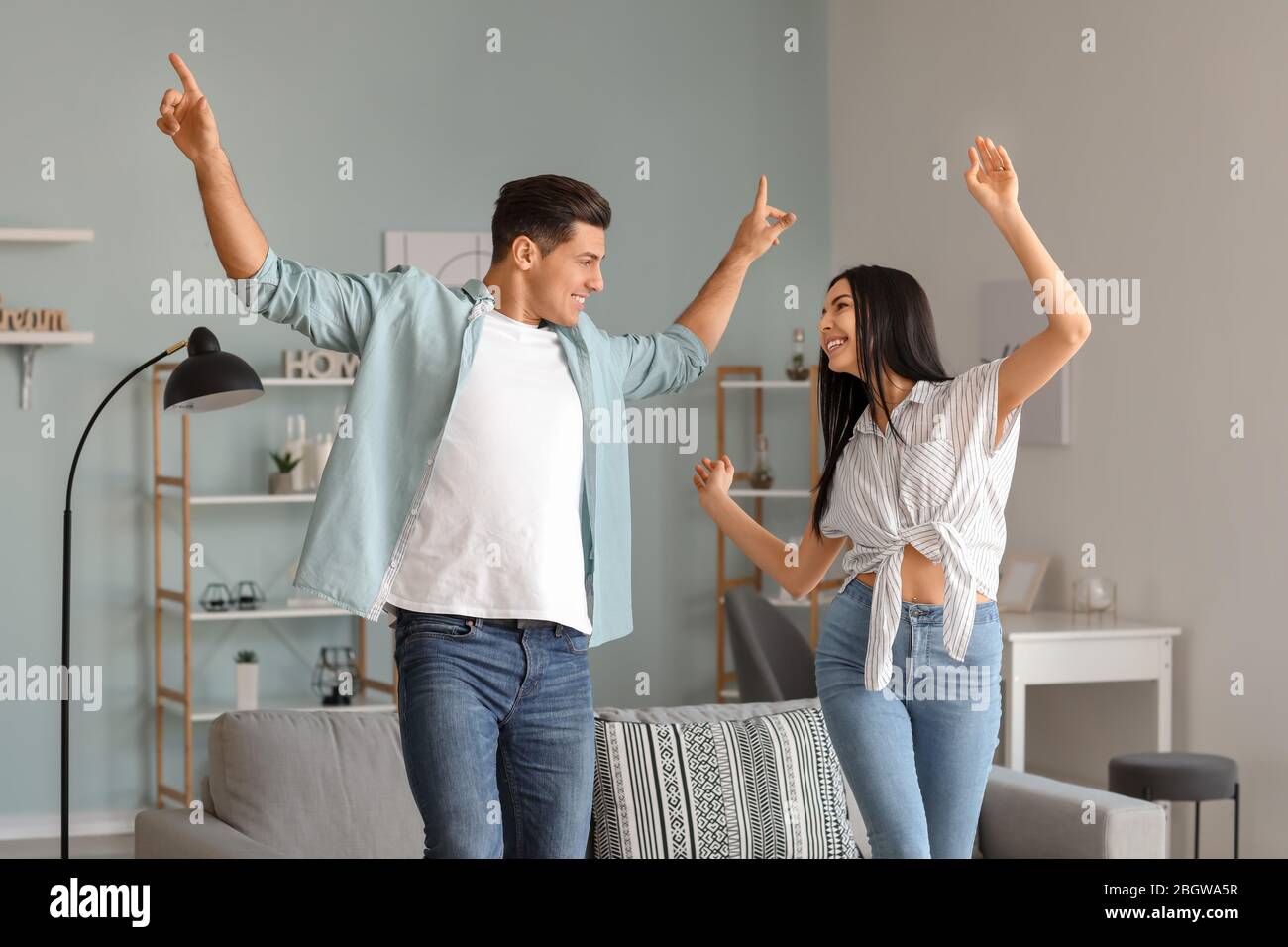 Happy young couple dancing at home Stock Photo - Alamy