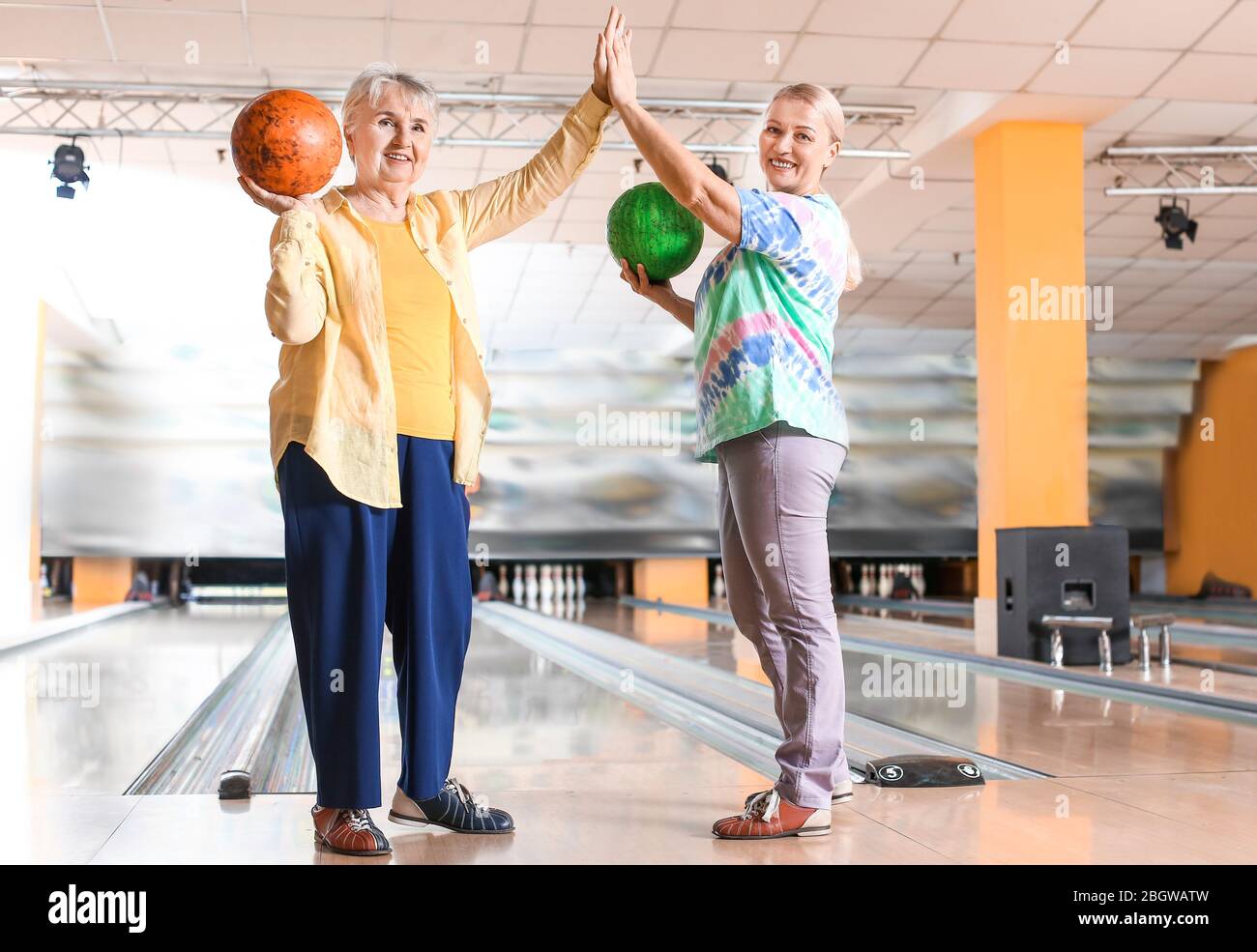 Senior women playing bowling in club Stock Photo - Alamy