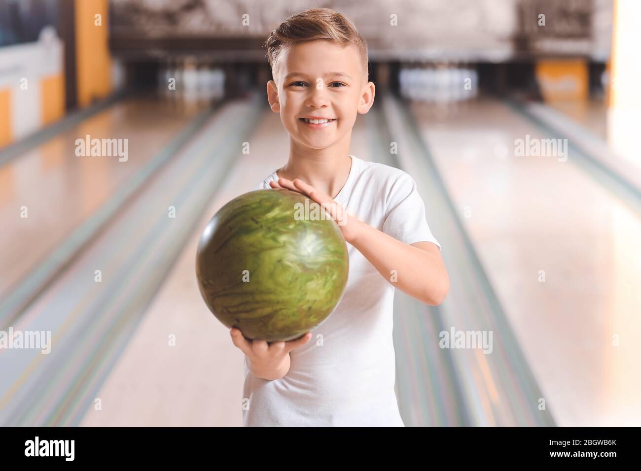 Little boy playing bowling in club Stock Photo - Alamy
