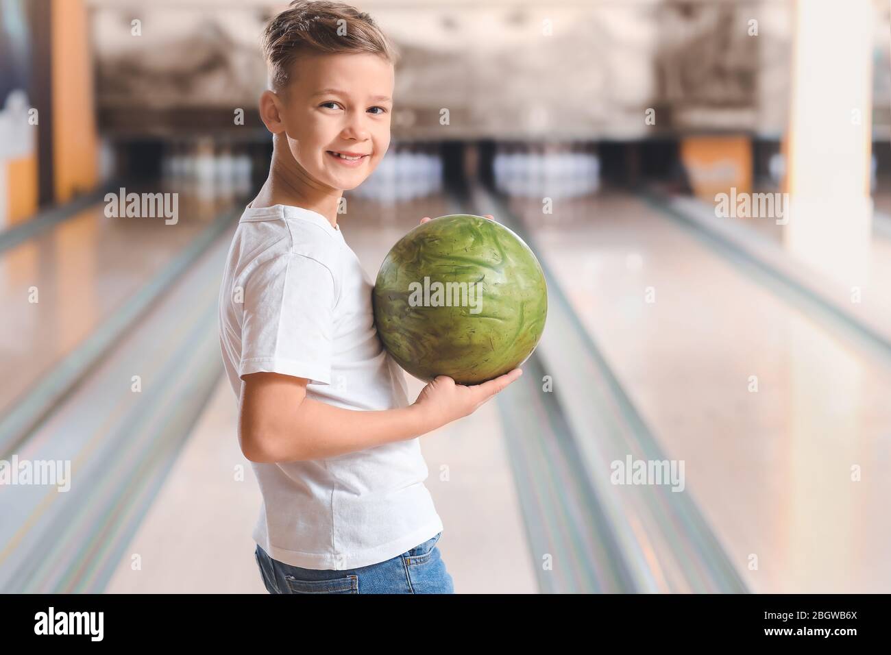 Little boy playing bowling in club Stock Photo - Alamy