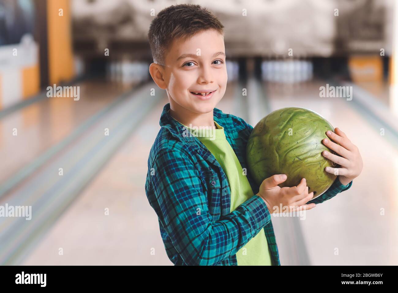 Little boy playing bowling in club Stock Photo - Alamy