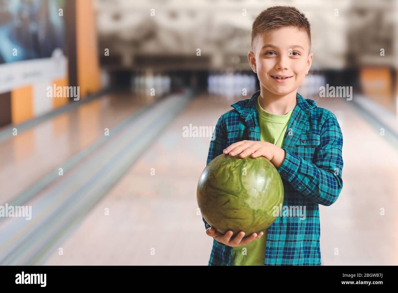 Little boy playing bowling in club Stock Photo - Alamy
