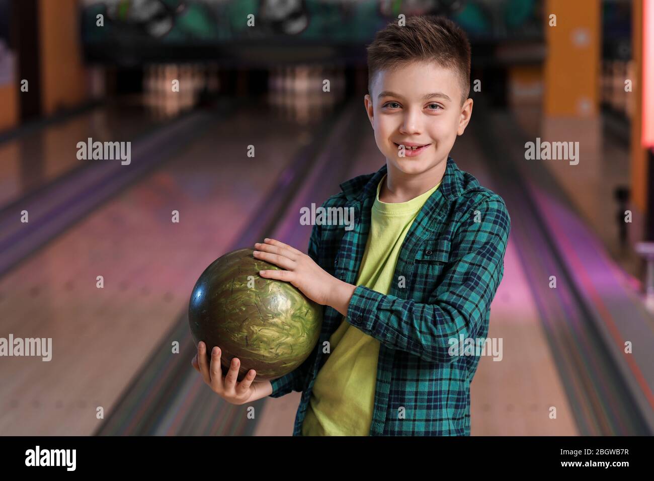 Little boy playing bowling in club Stock Photo - Alamy