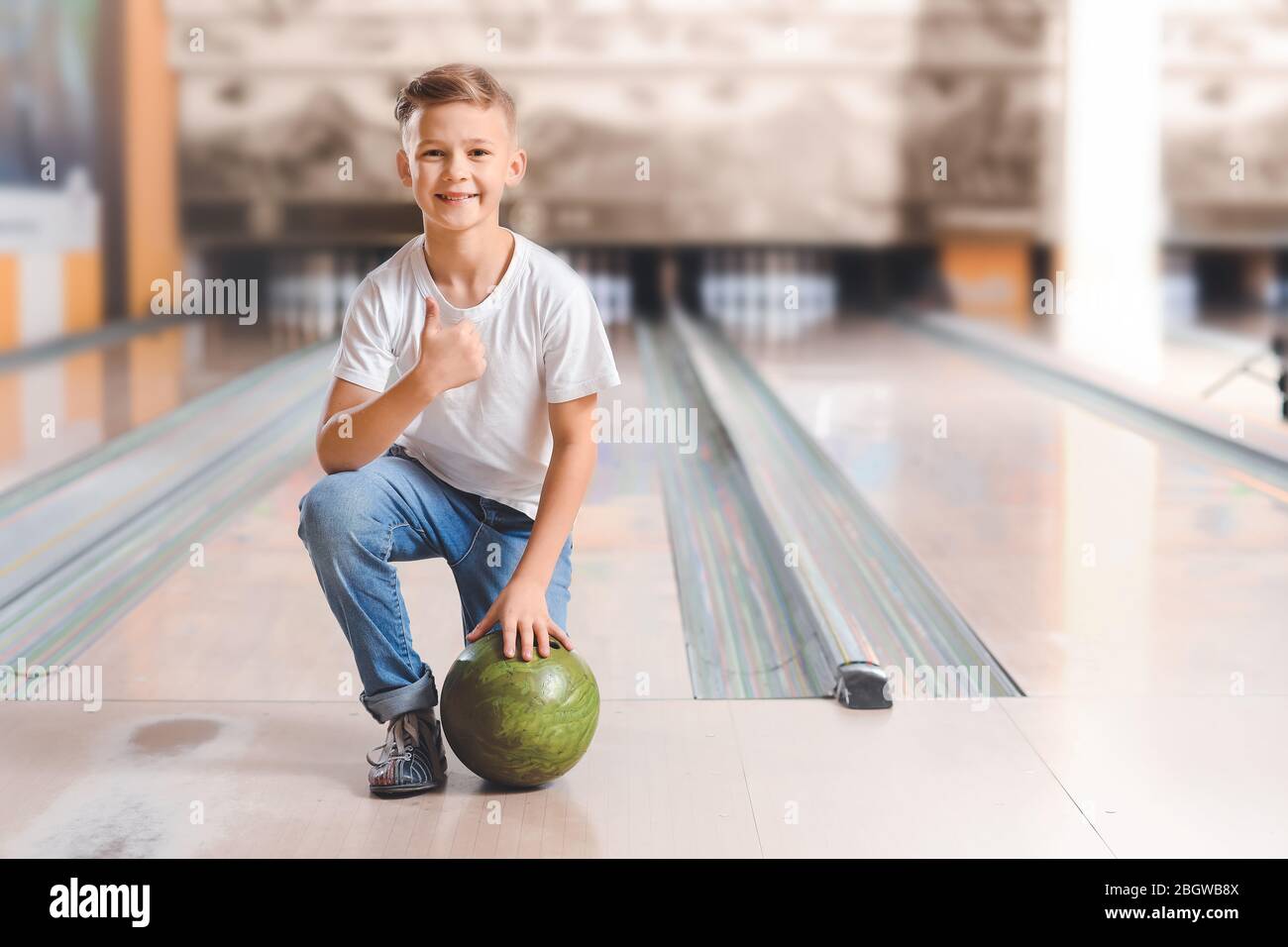 Little boy playing bowling in club Stock Photo - Alamy
