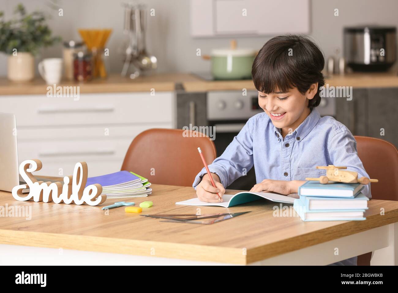 Little boy doing homework in kitchen Stock Photo - Alamy