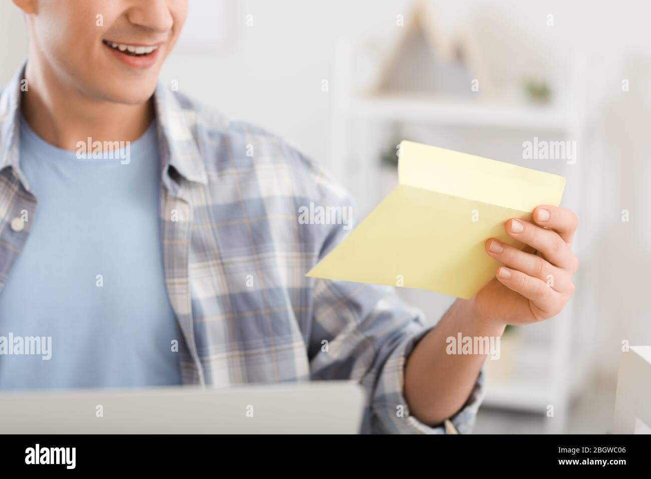 Young man reading letter at home Stock Photo - Alamy