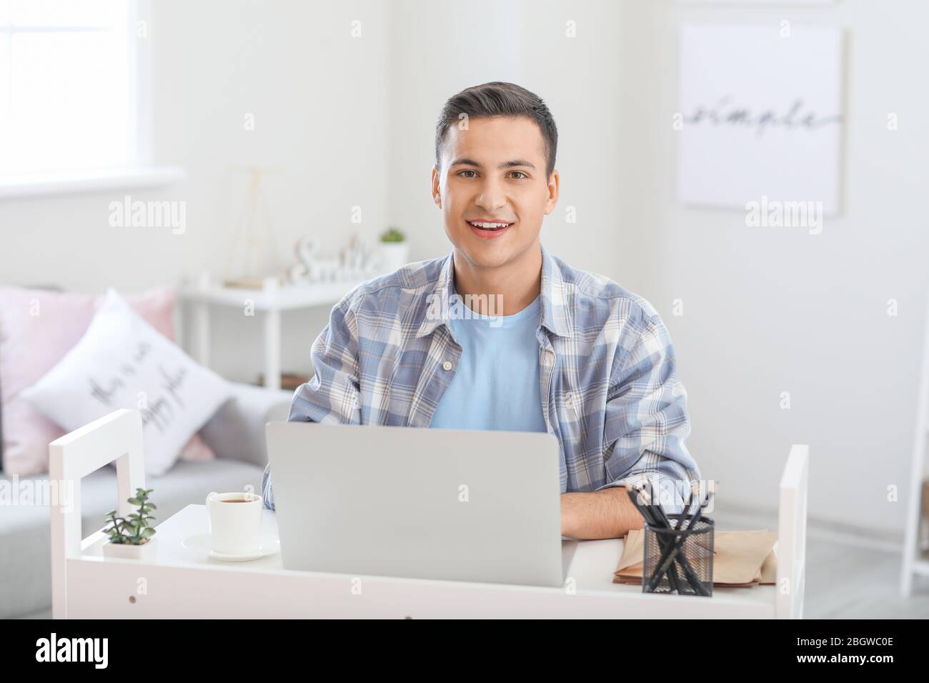 Young man with laptop checking his e-mail at home Stock Photo - Alamy