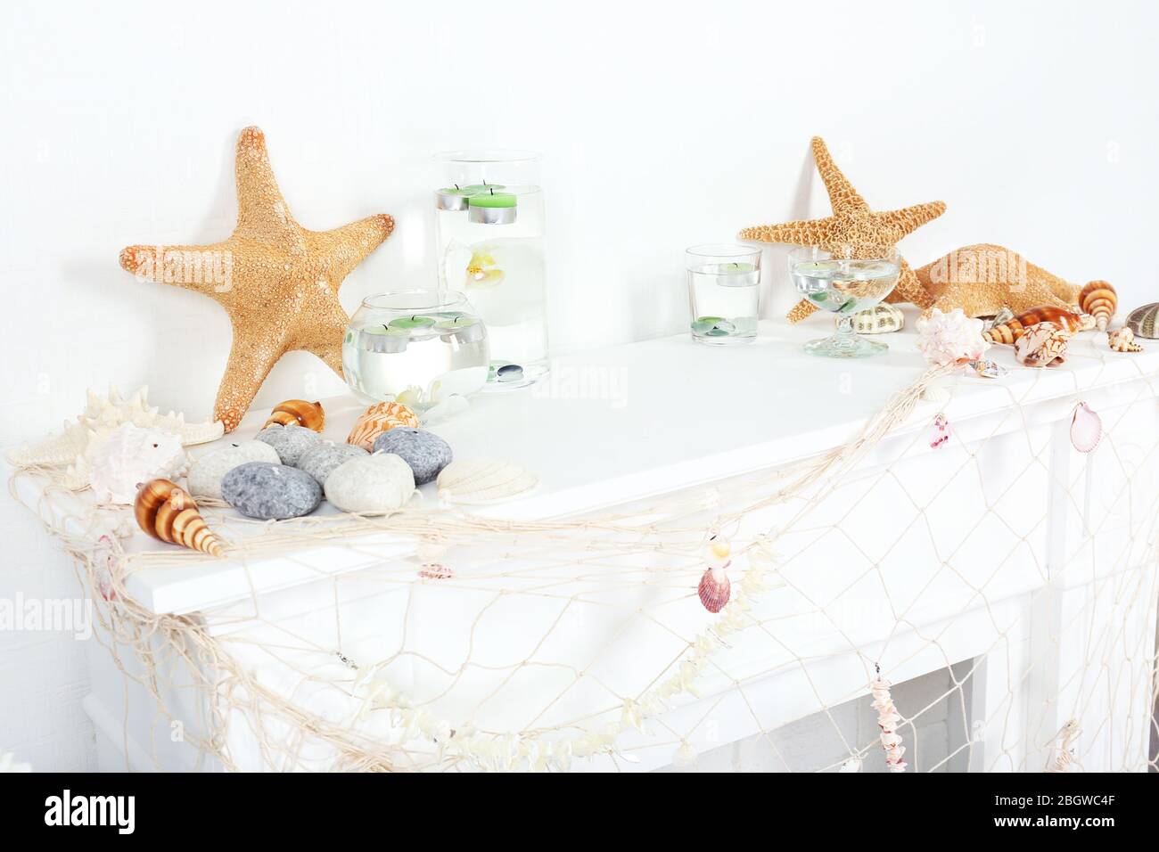 Different sea objects on white shelf in living room Stock Photo - Alamy