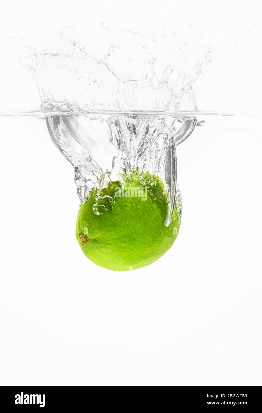 Falling of fresh lime into water against white background Stock Photo ...