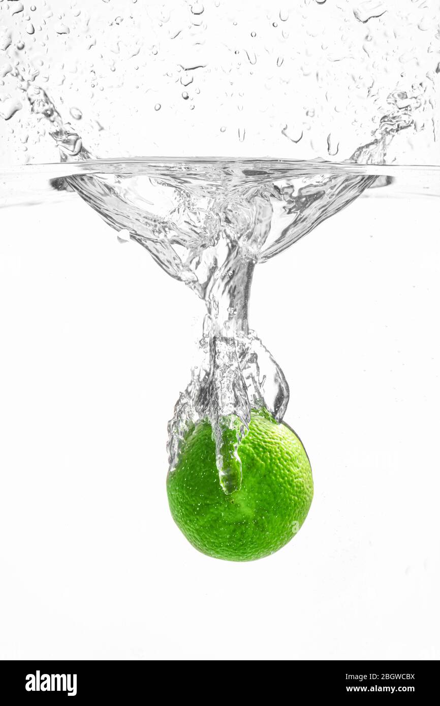 Falling of fresh lime into water against white background Stock Photo ...