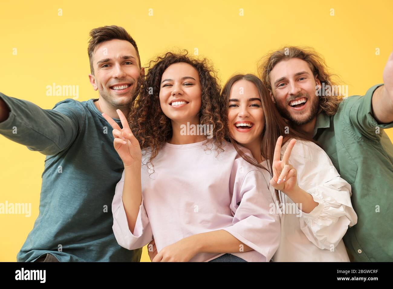 Friends taking selfie on color background Stock Photo - Alamy