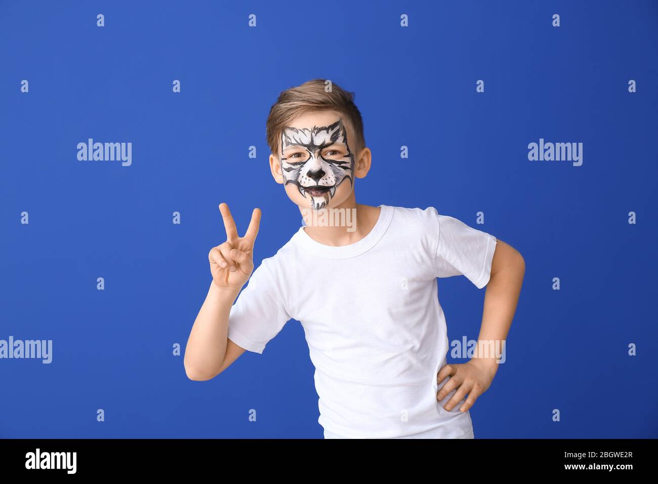 Funny little boy with face painting on color background Stock Photo - Alamy
