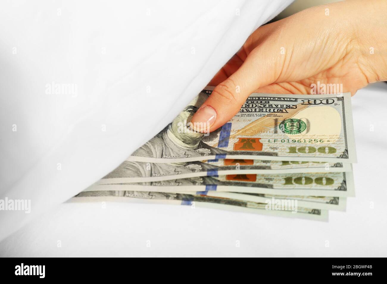 Woman hiding money bed hi-res stock photography and images - Alamy