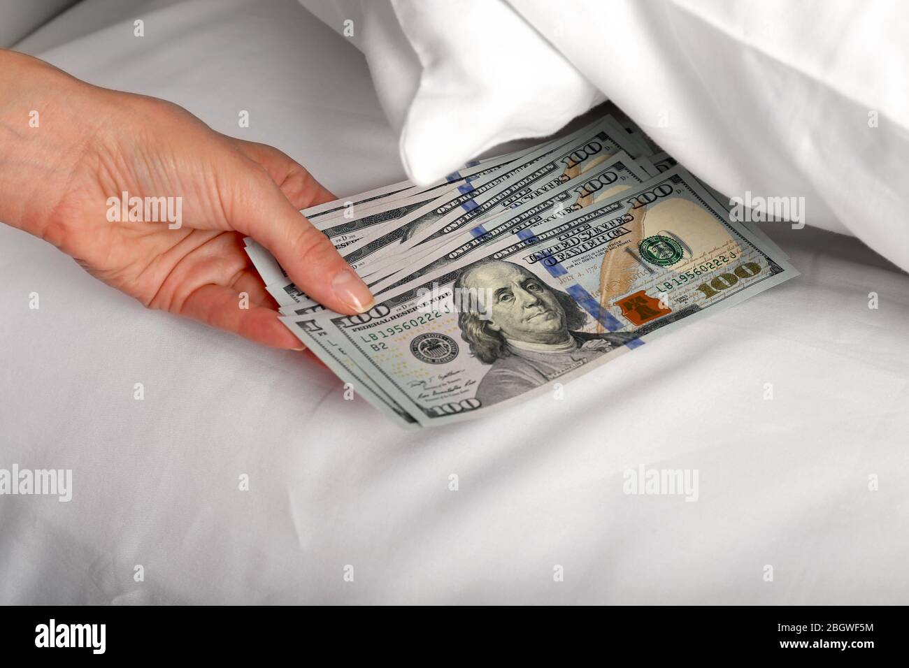 Woman hiding money bed hi-res stock photography and images - Alamy