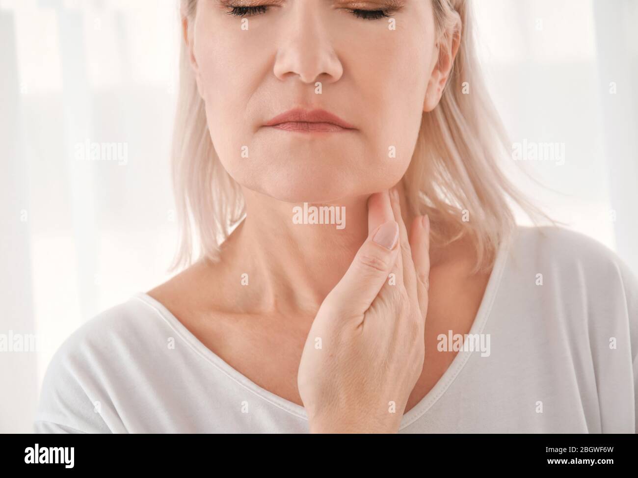 Woman with thyroid gland problem at home Stock Photo - Alamy