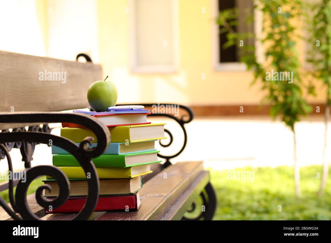 Stacked books on bench, outside Stock Photo - Alamy