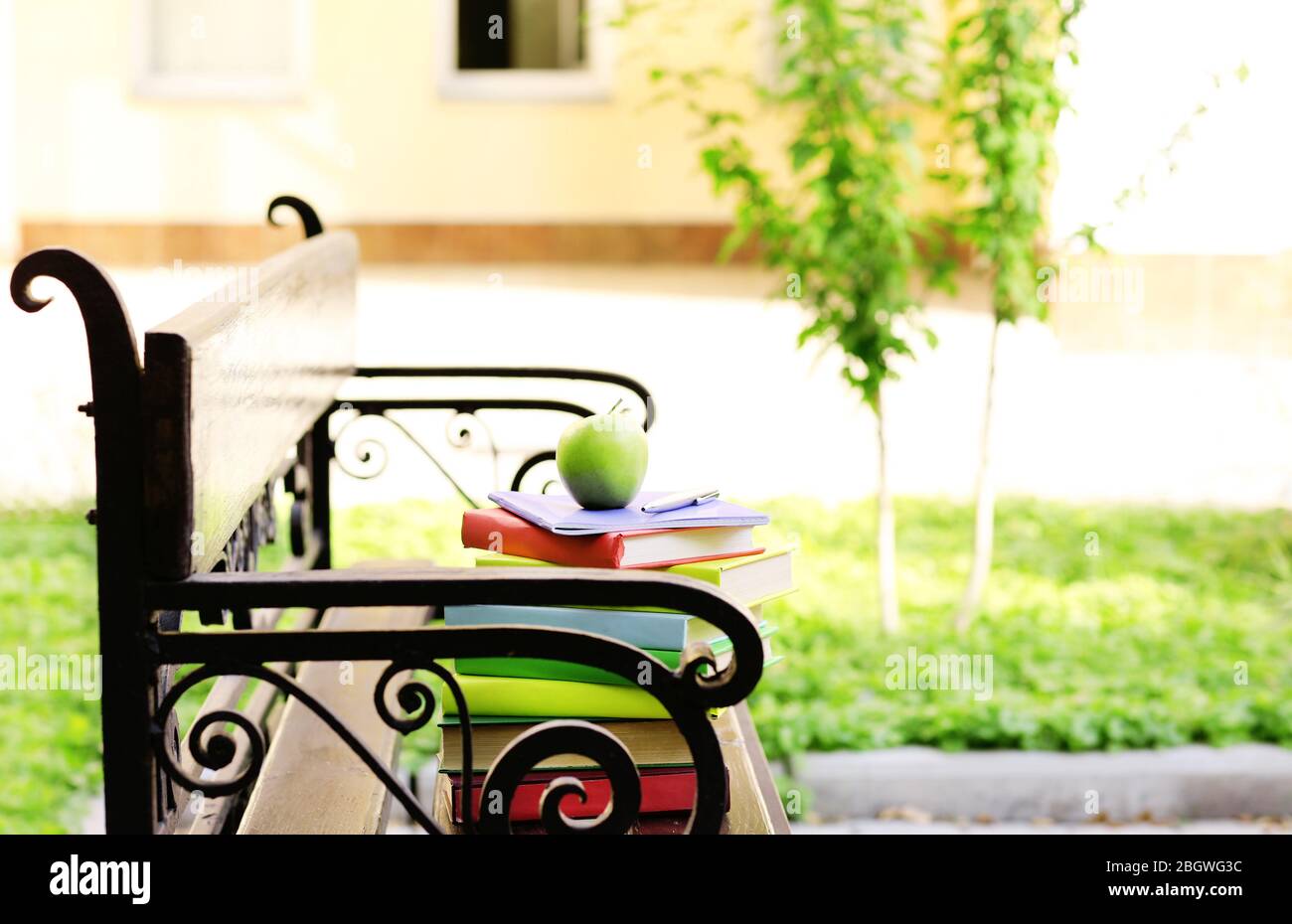 Stacked books on bench, outside Stock Photo - Alamy