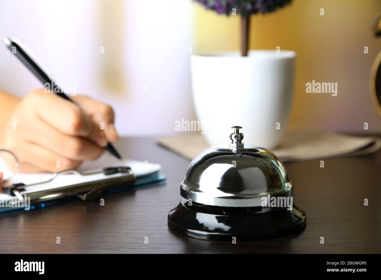 Female hand writing in Hotel guest book on reception desk, on bright ...