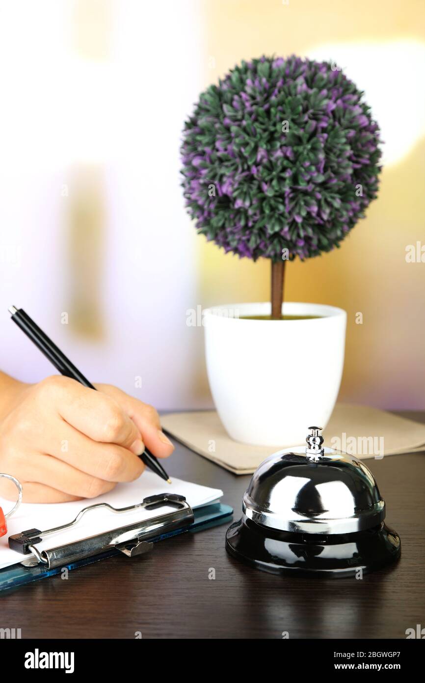Female hand writing in Hotel guest book on reception desk, on bright ...