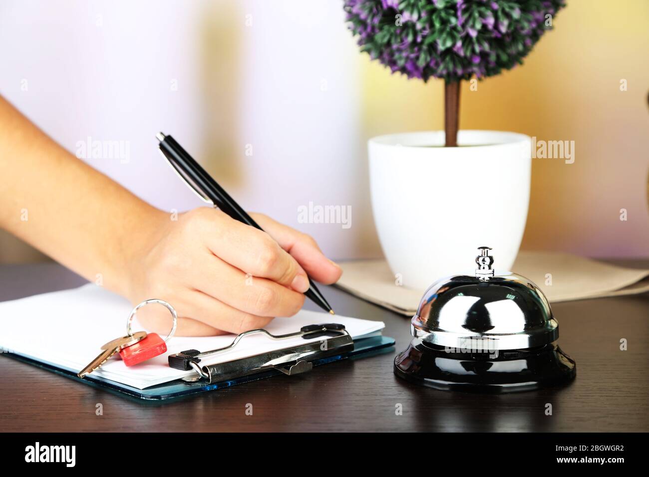 Female hand writing in Hotel guest book on reception desk, on bright ...