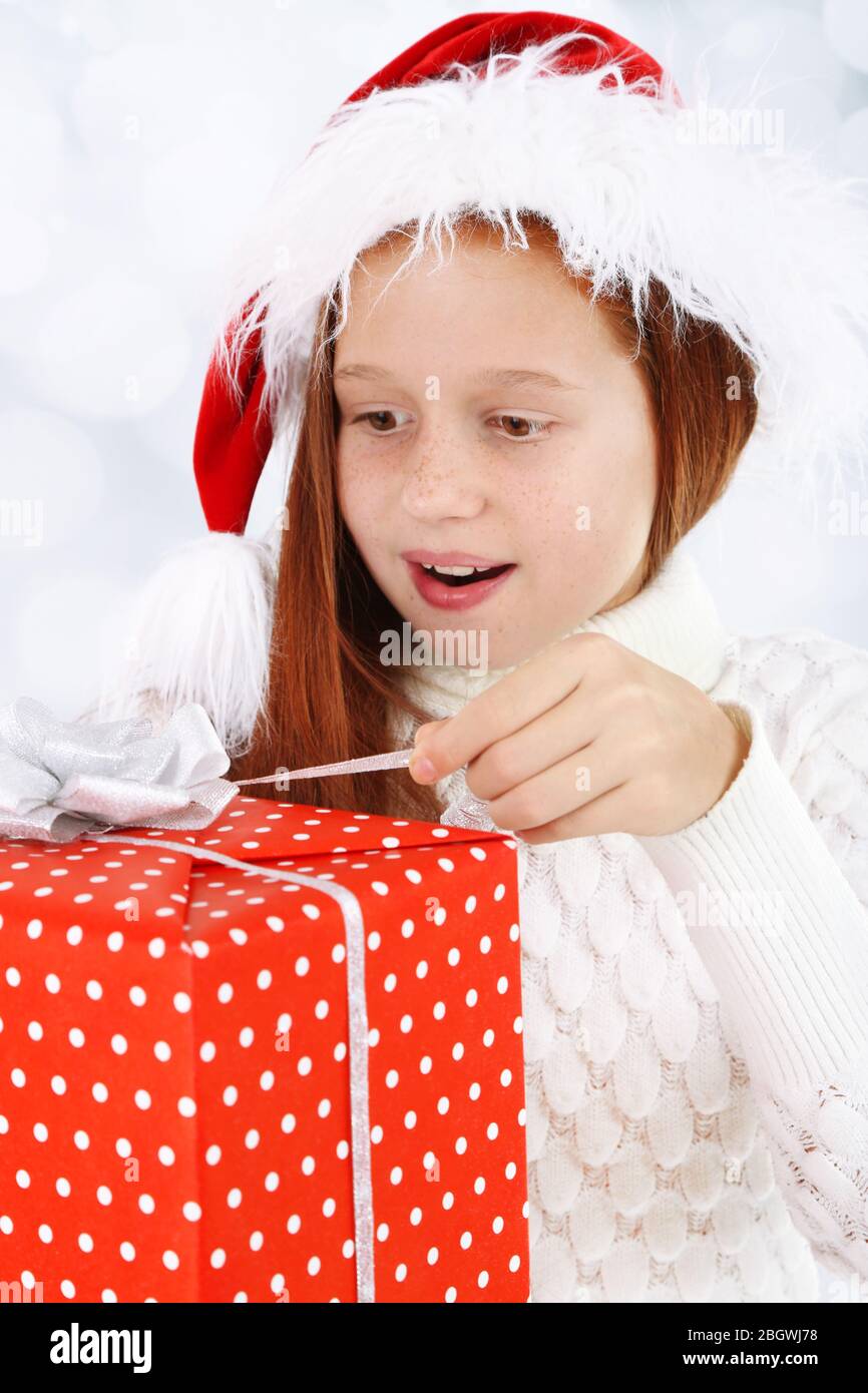 Beautiful little girl with present box on bright background Stock Photo ...