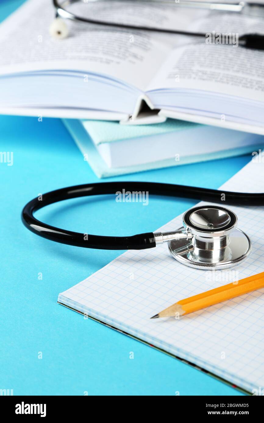 Medical stethoscope with notepad and books on blue background Stock ...