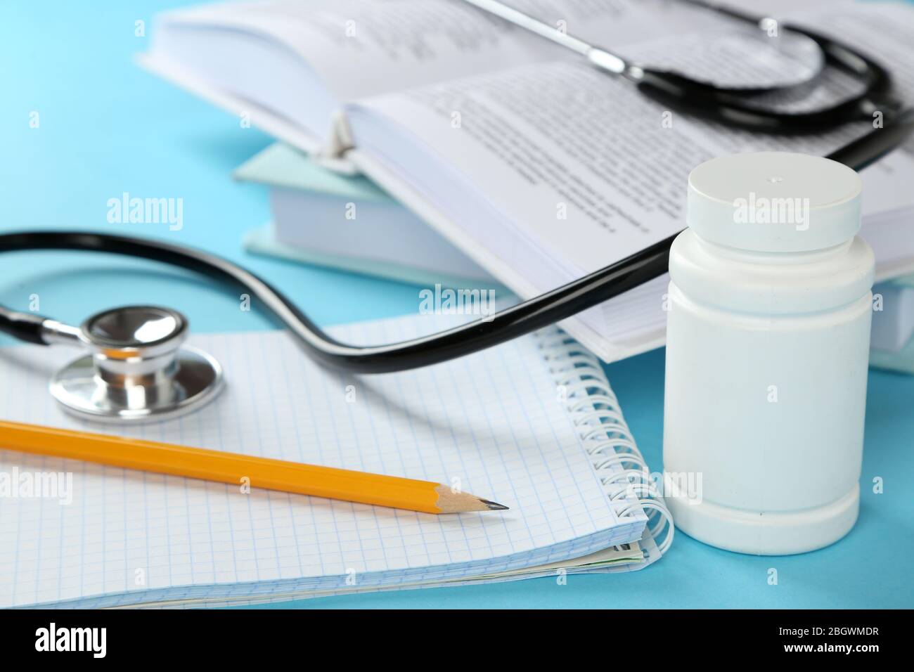 Medical stethoscope with notepad and books on blue background Stock ...